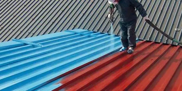 Робочий завдає фарбувальну гідроізоляцію на дах