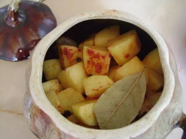 Skivad rå potatis med laurelplåt och hammare paprika i keramisk skal