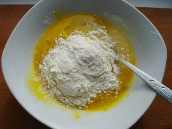 Tepung gandum dalam mangkuk dengan campuran gula-telur