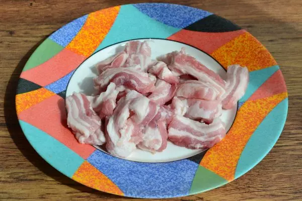 Шматочки свіжої свинячої грудинки на тарілці