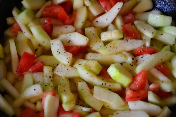Fette di zucchine e pomodori, sale spruzzato e pepe macinato nero