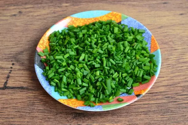 Finely chopped green onions in a plate on the table