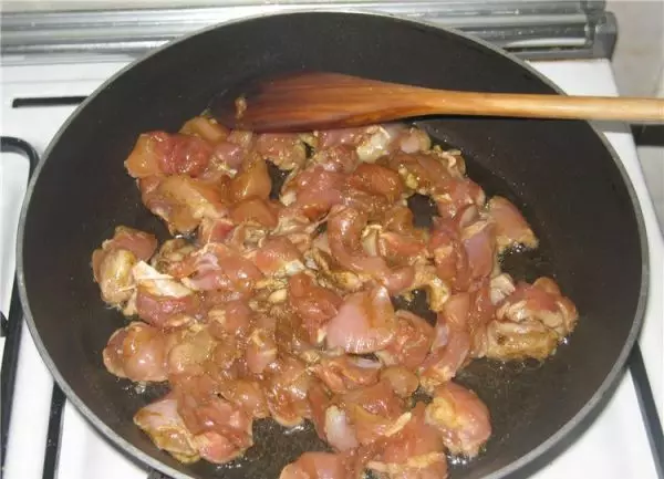 Шматочки курячого м'яса в сковороді