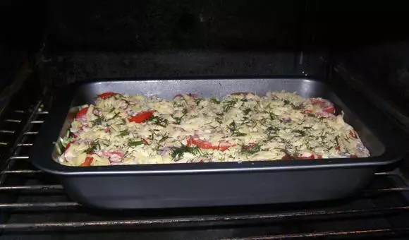 Metal shape with zucchini casserole on oven grid