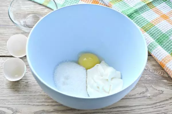 Jaune d'œuf, sucre et crème sure dans un bol bleu
