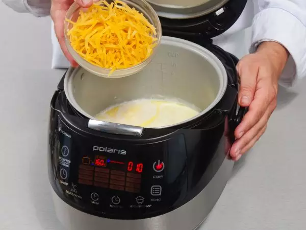 Multicooker dengan susu di dalam mangkuk dan bekas kaca kecil dengan pasta kering di tangan manusia