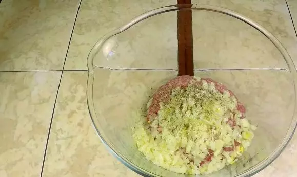 未加工的切碎的切碎的蔥，大蒜和香料在桌上的一個玻璃碗