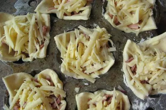 Billets för snacks från ett puffdekor med riven fast ost och andra ingredienser i form för framställning av delmuffin