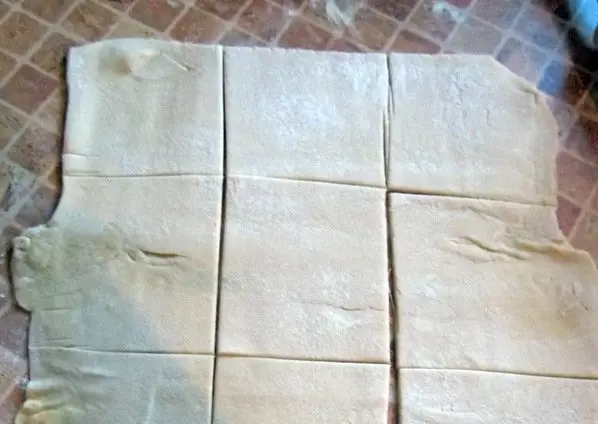 Lençóis quadrados de massa de camada na superfície de trabalho da mesa da cozinha