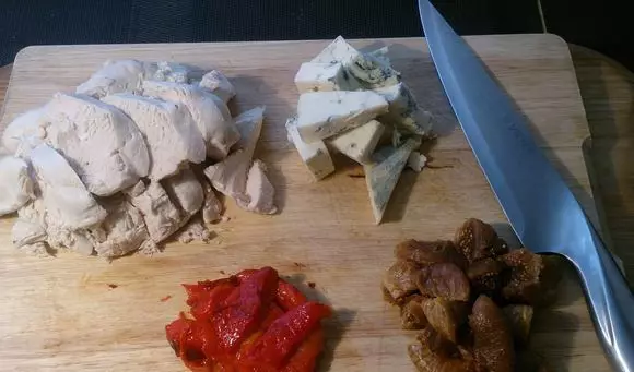 Порізані на шматочки продукти для курячого паштету на обробній дошці з ножем