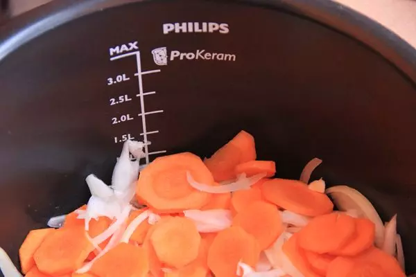 Morötter och lök i en skål med mångfärgare