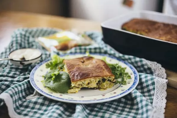 Un morceau de gâteau filaire avec du chou sur une assiette avec des verts