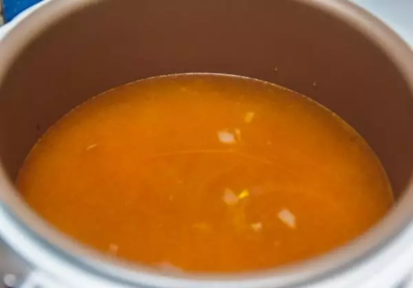 Agua con salsa de tomate y verduras en una olla lenta.