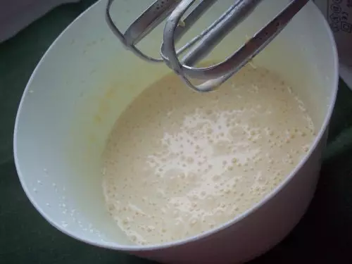 Telur whipped dalam mangkuk dan pengadun putih