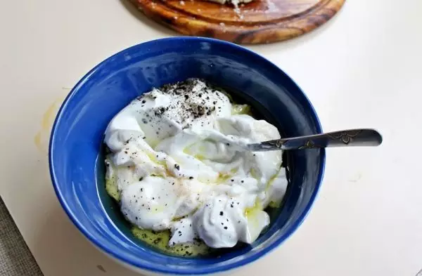 Framställning av tankning från yoghurt, vegetabilisk olja och kryddor i en liten blå behållare