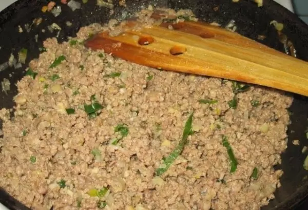 Pečené mleté ​​maso s lukem v pánvi a dřevěné čepele