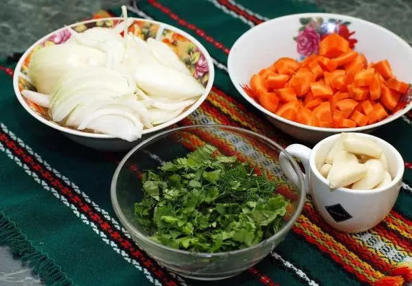Підготовлені овочі та свіжа зелень в різних ємностях на столі