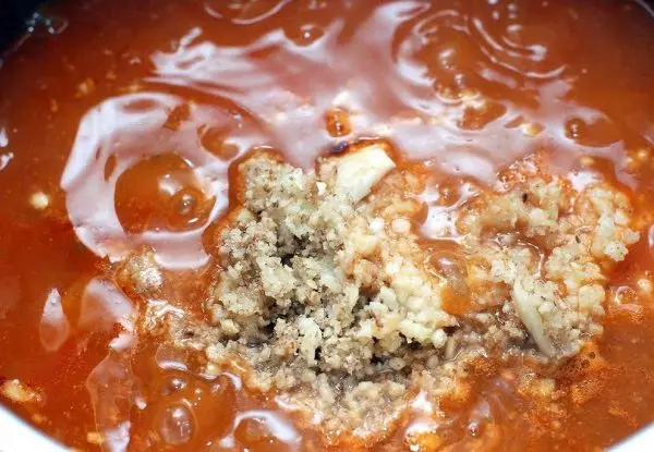 Cassiere da noce-aglio in una casseruola con zuppa