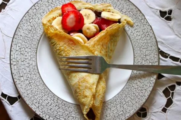 Panqueques en un galope con frutas y bayas.