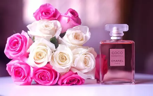 Bouquet de rósanna bán-bándearg agus buidéal biotáille chanel mademoiselle