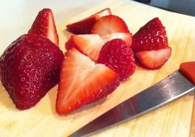 एक कटिंग बोर्ड वर स्ट्रॉबेरी