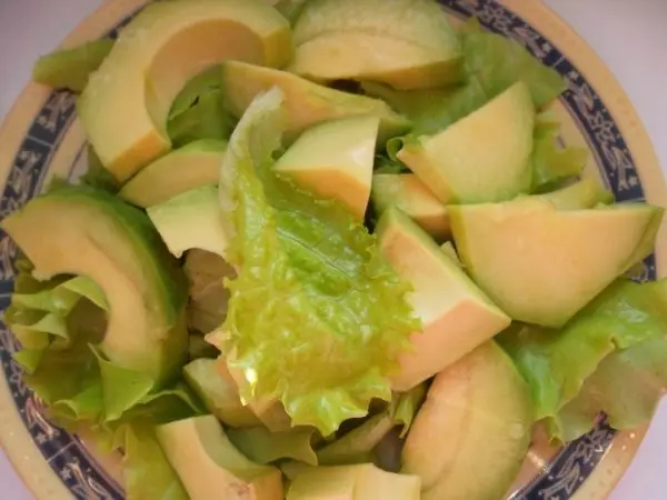 Plakjes avokado en stikken saladeblêden yn in lyts plaat