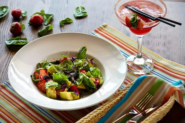 Салат з авокадо і полуниці на красиво сервірованому столі