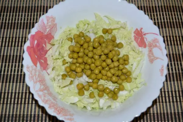 Bolinhas verdes enlatadas e listras fatiadas Repolho de Pequim em uma placa na mesa