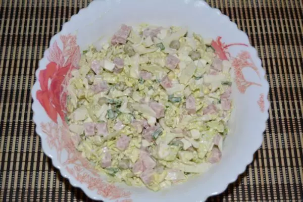 Beijing repolyo salad na may ham, mga gisantes at mayonesa sa plato