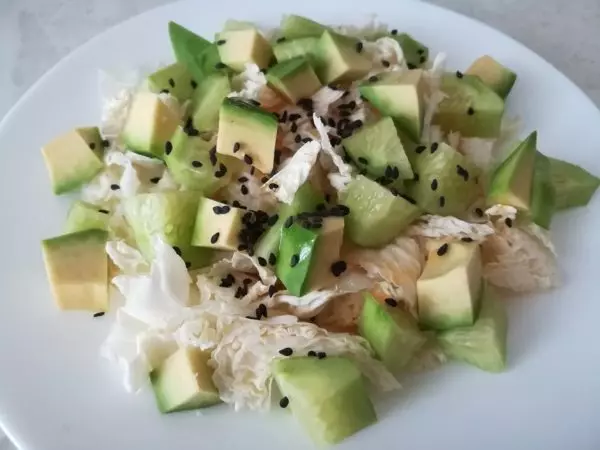 Salada de repolho de Pequim com pepino, abacate e gergelim em uma placa branca