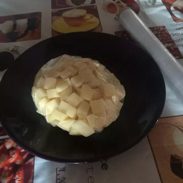 Penyimpanan kentang yang disucikan dalam filem makanan di dalam peti sejuk