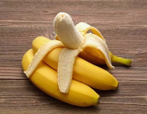Половина прочистена банана лежи на два други